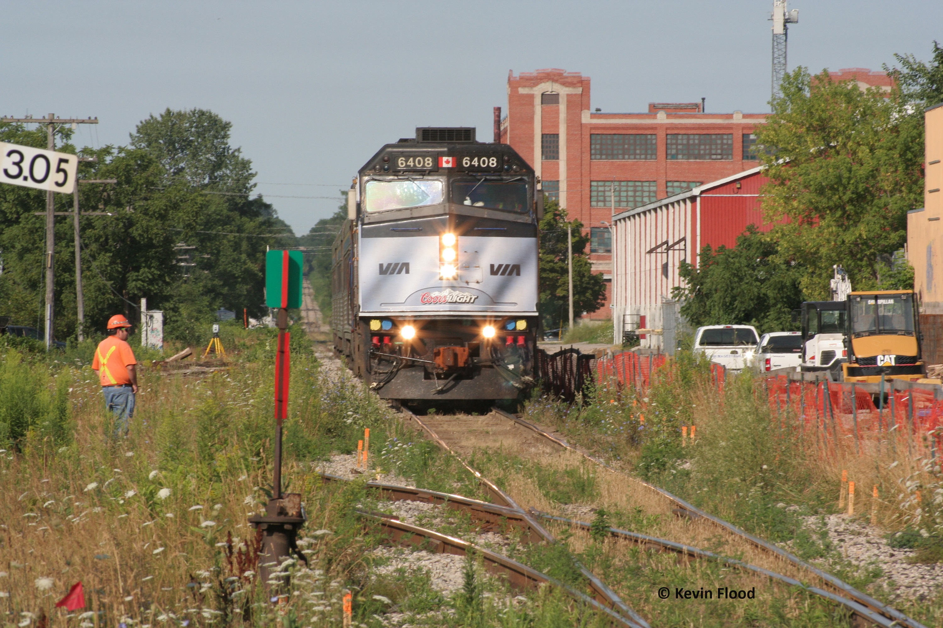 Railpictures.ca - Kevin Flood Photo: In August 2011, a surveyor looks on as VIA 84 eases towards ...